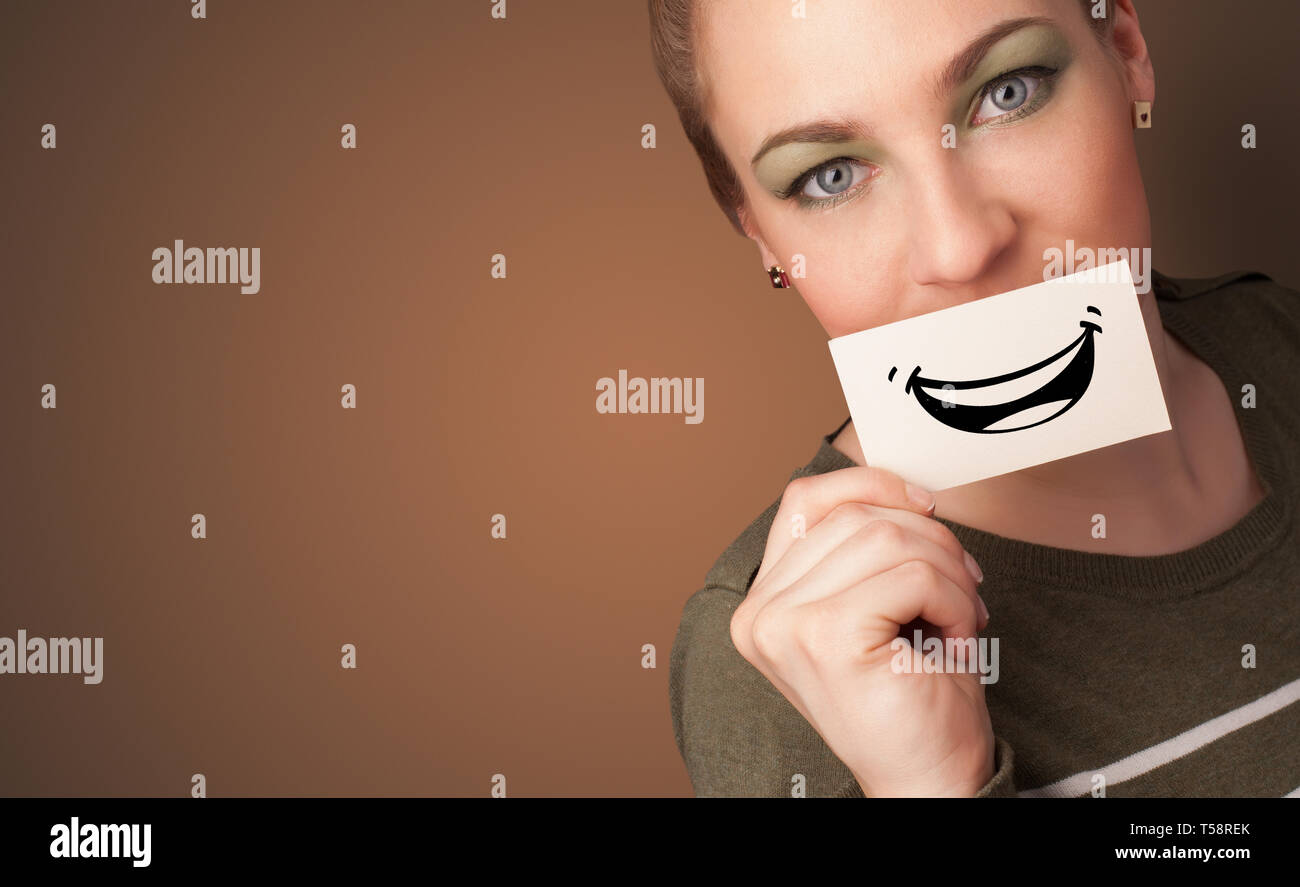Person holding card in front of his mouth with ironic smile Stock Photo ...
