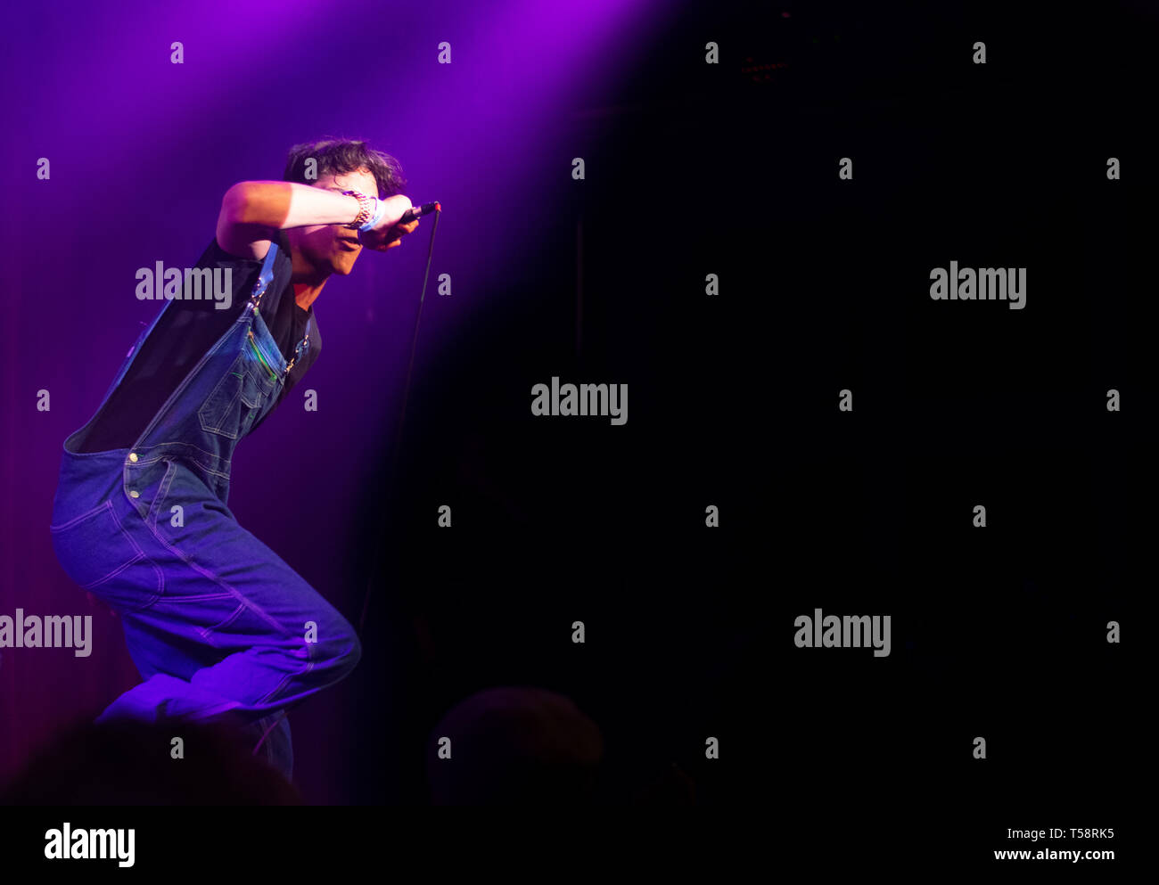 Singing man playing loud concert with microphone in hand Stock Photo ...