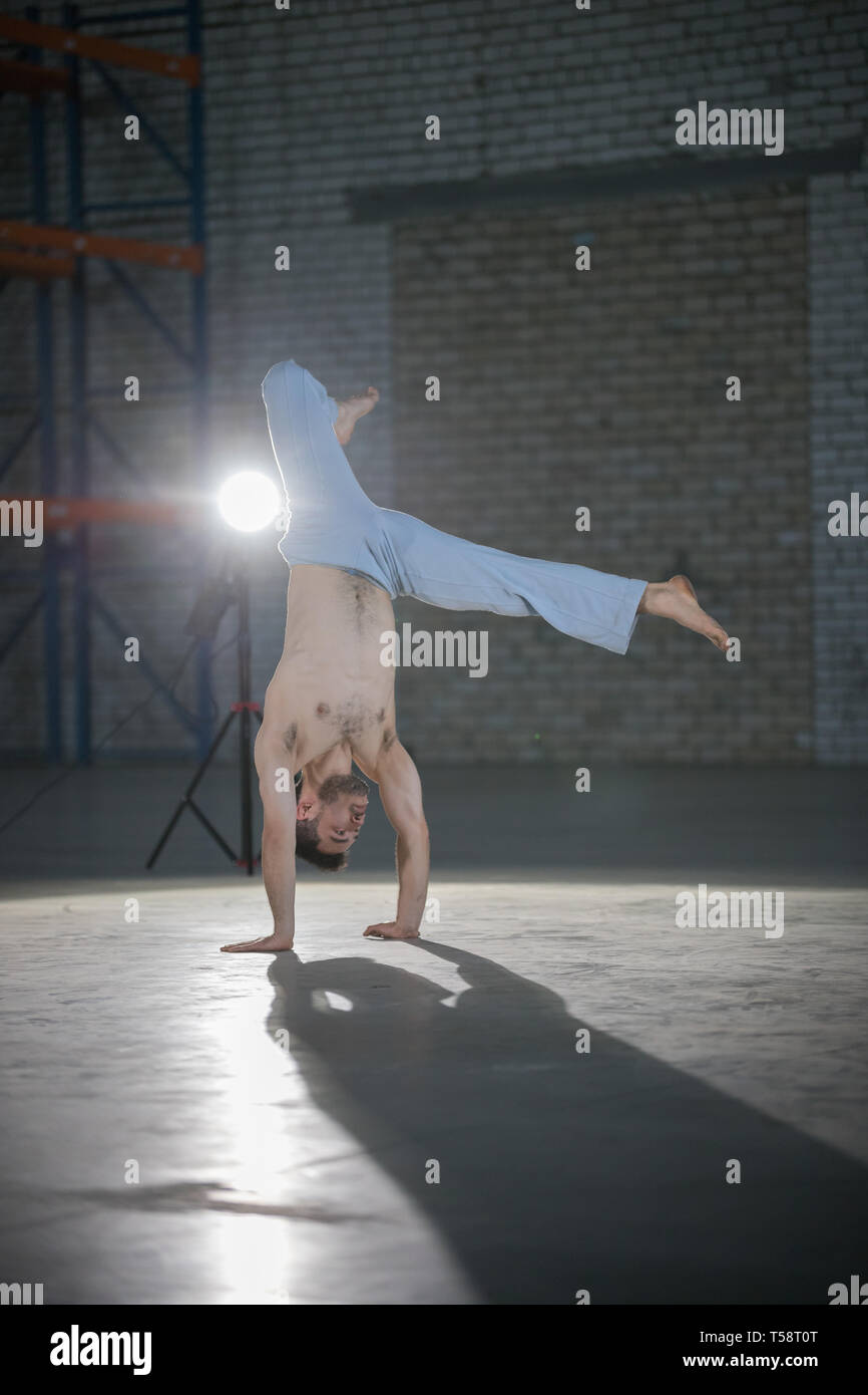 An athletic man on capoeira training. Staning in the pose. Standing on ...