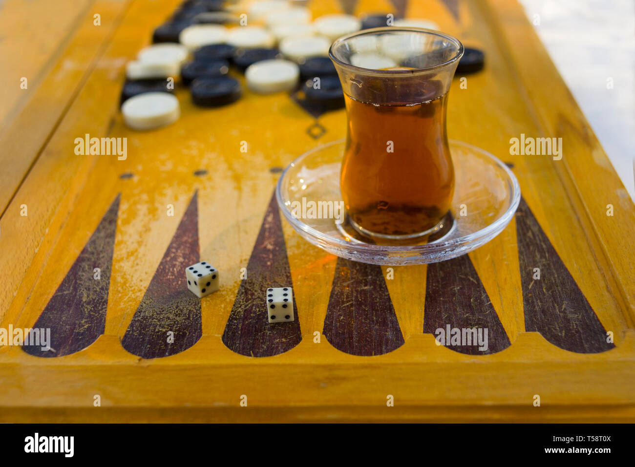 Playing backgammon and having traditional turkish tea, outdoor close-up ...
