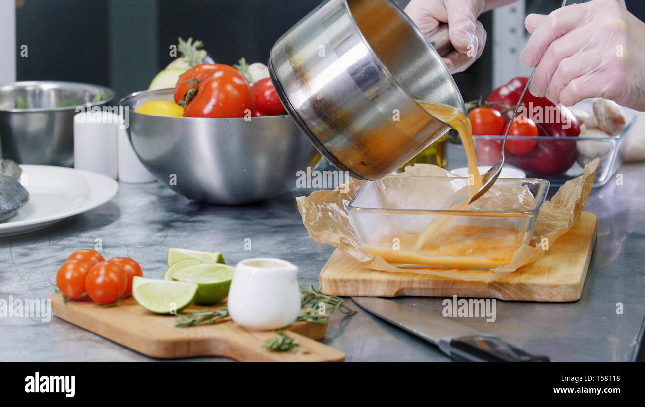Restaurant kitchen. Chef pouring soup in the glass deep plate Stock ...