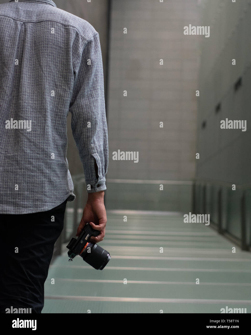 Boy with camera walking away Stock Photo - Alamy