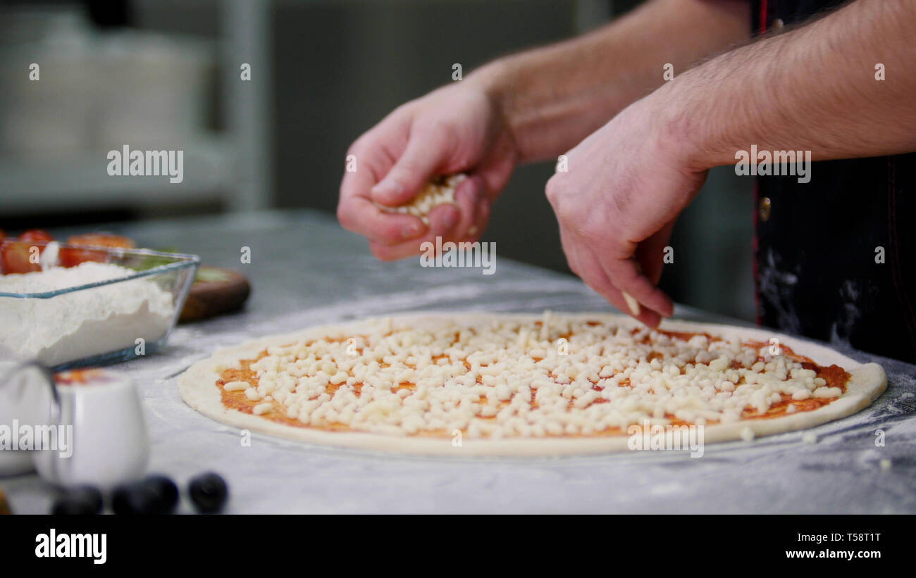 Chef putting cheese on pizza hi-res stock photography and images - Alamy