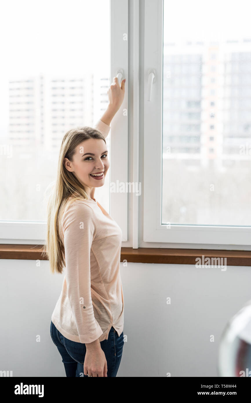 Beautiful woman opening window in the morning Stock Photo - Alamy