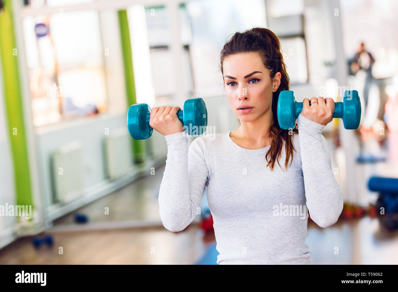 Beautiful athletic girl exercising in a gym.Young woman with fit body ...