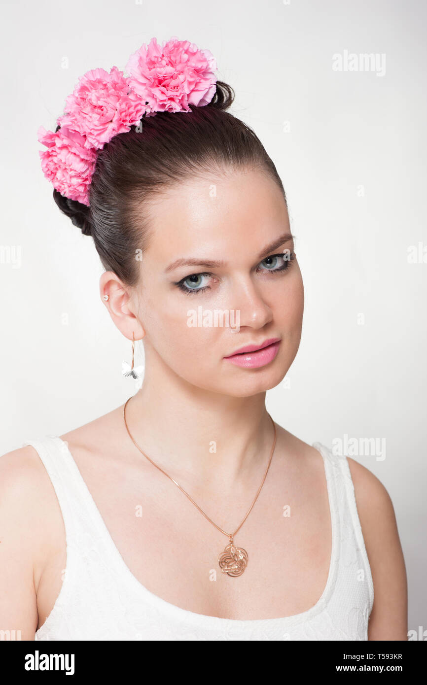 Portrait of young woman with flower diadem on her head over white ...