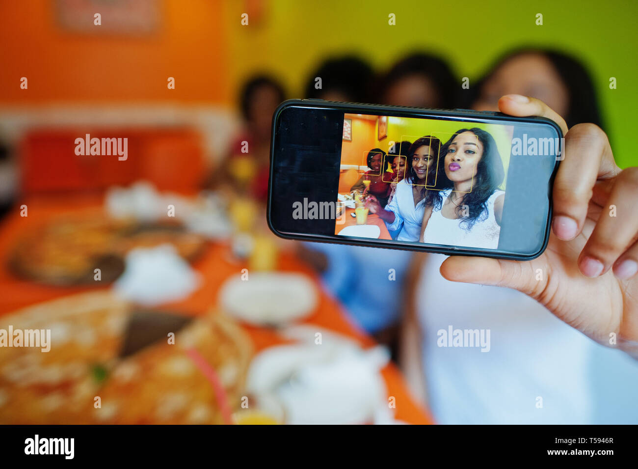 Close up photo phone screen of four young african girls in bright ...