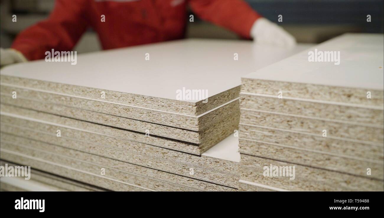 Dvp production. Worker with boards in a factory. The young master folds ...
