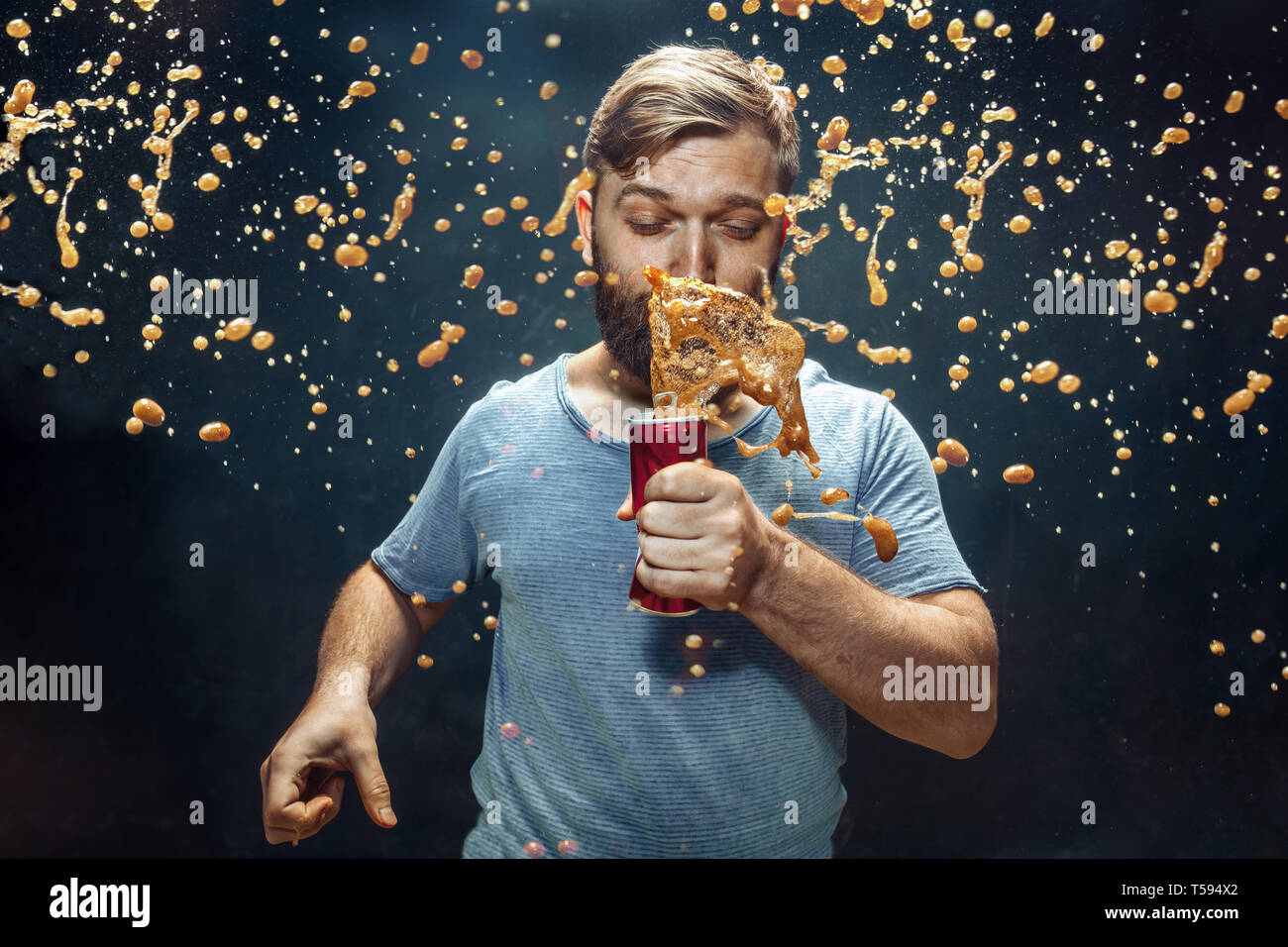 Man drinking a cola at studio. Young smiling happy caucasian guy ...