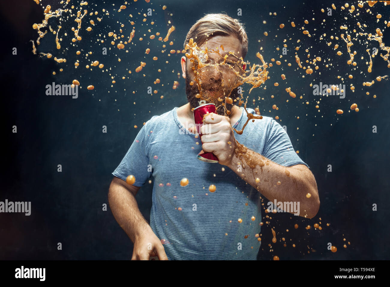 Man drinking a cola at studio. Young smiling happy caucasian guy ...