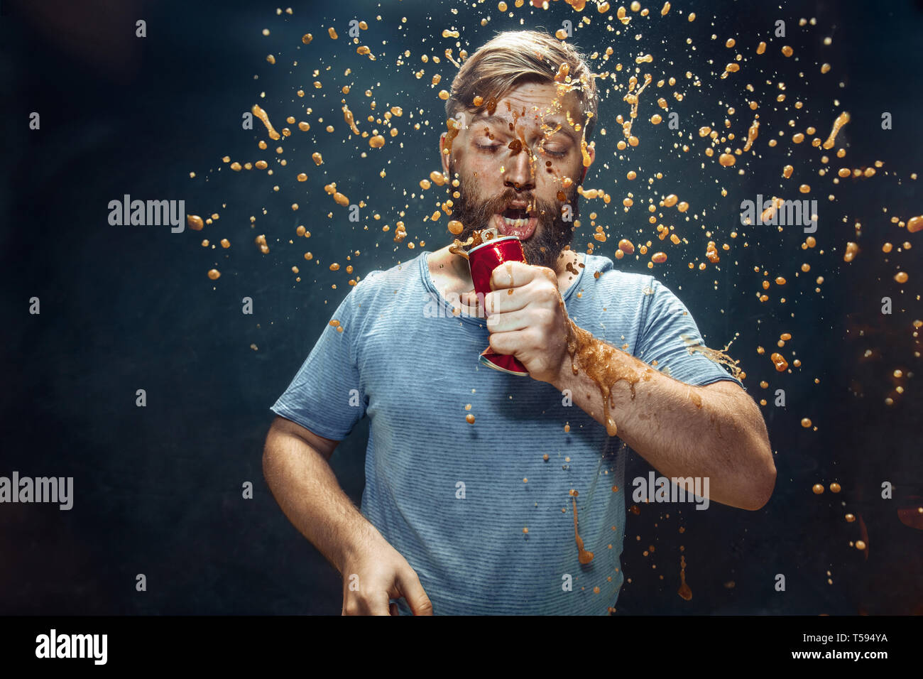 Man drinking a cola at studio. Young smiling happy caucasian guy ...