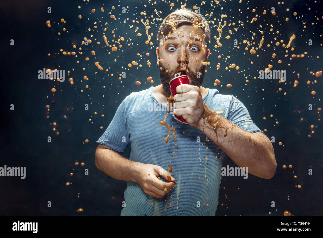 Man drinking a cola at studio. Young smiling happy caucasian guy ...