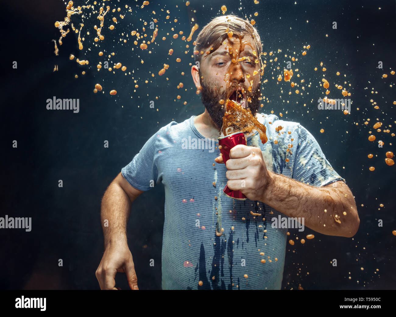 Man drinking a cola at studio. Young smiling happy caucasian guy ...