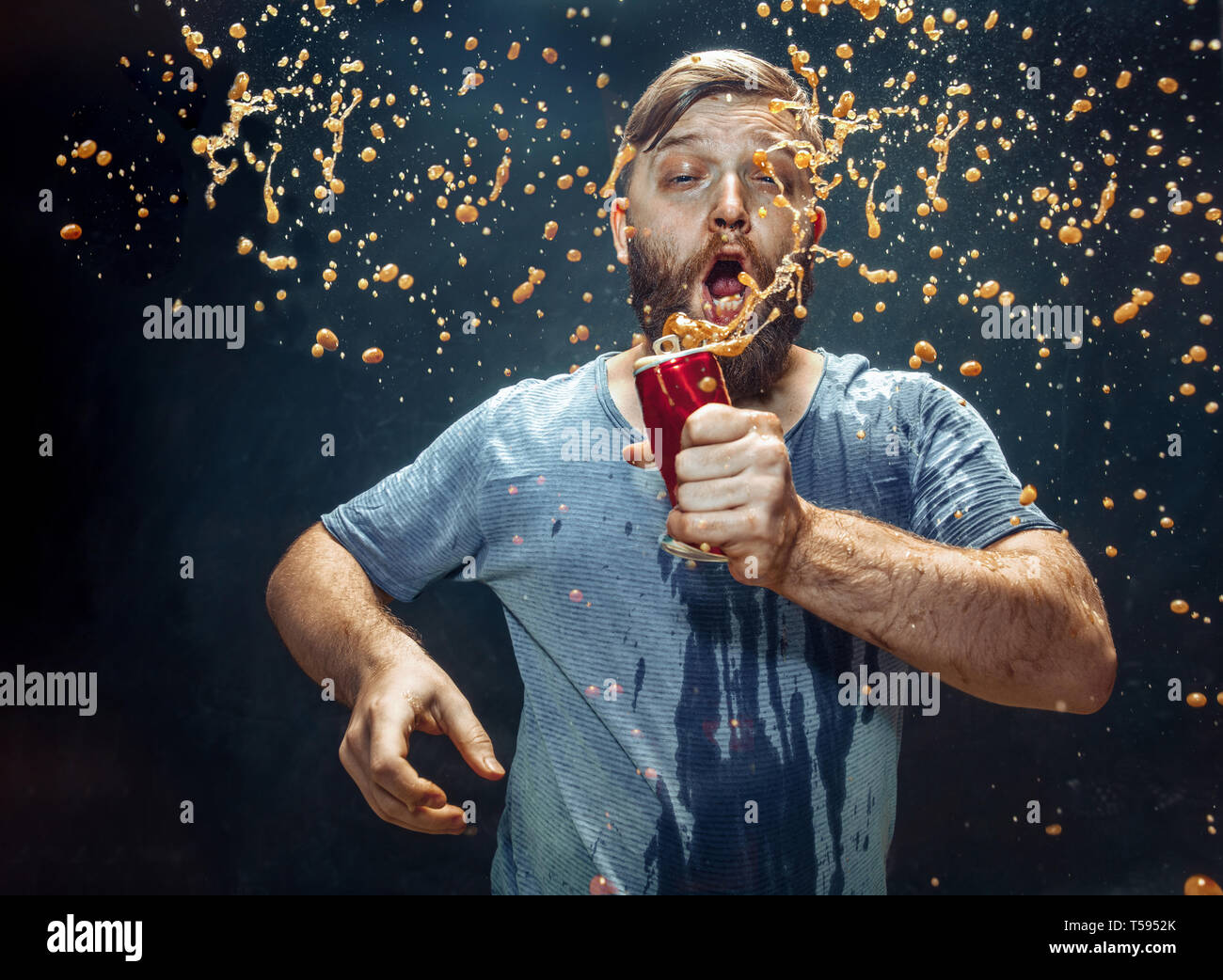 Man drinking a cola at studio. Young smiling happy caucasian guy ...