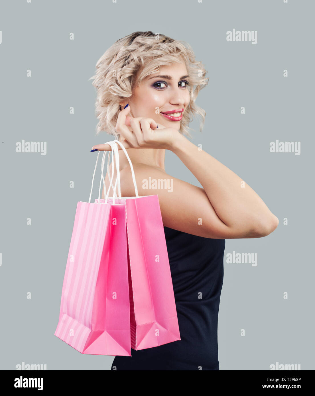 Happy model woman holding pink shopping bag Stock Photo - Alamy