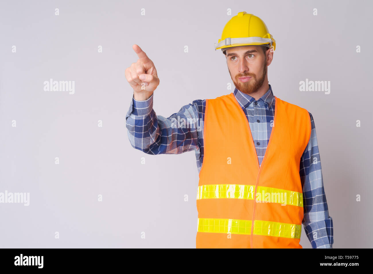 Portrait of young bearded man construction worker directing and ...