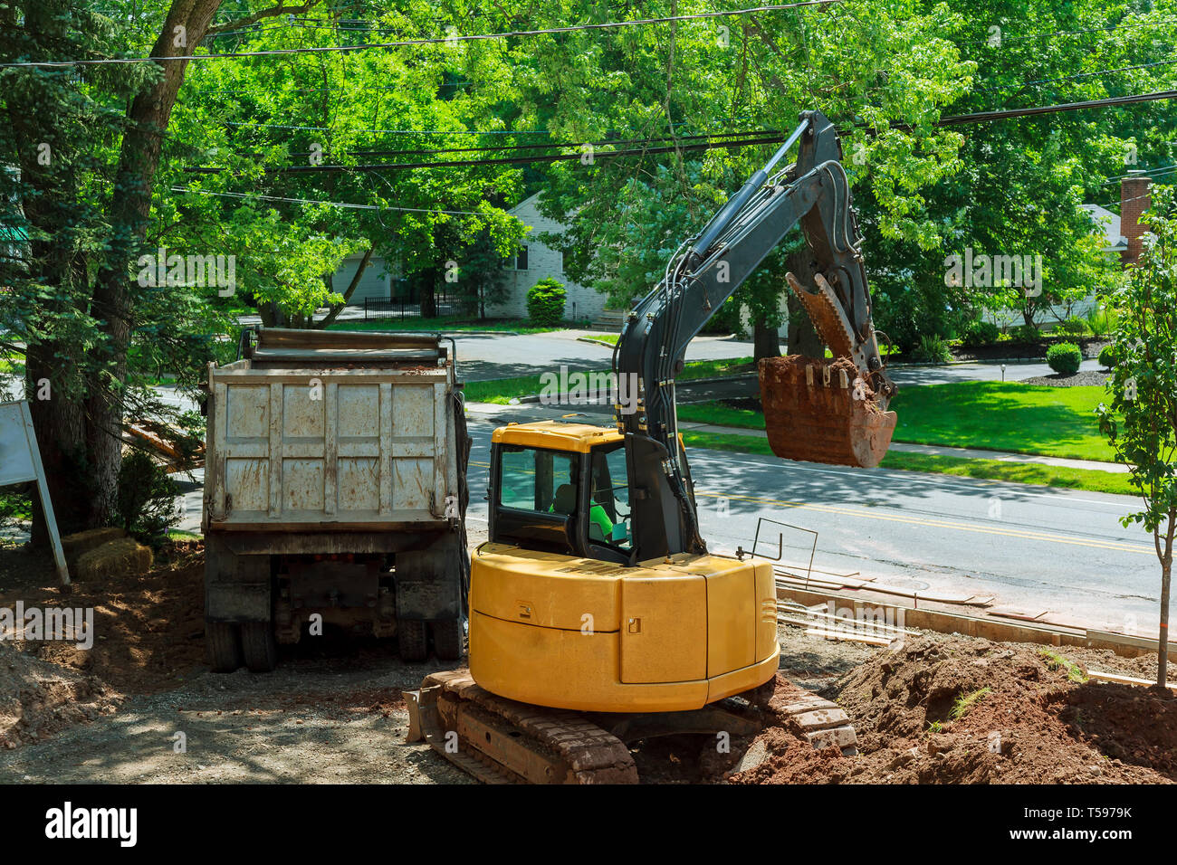 Yellow heavy duty digger working in excavation pit on background of ...