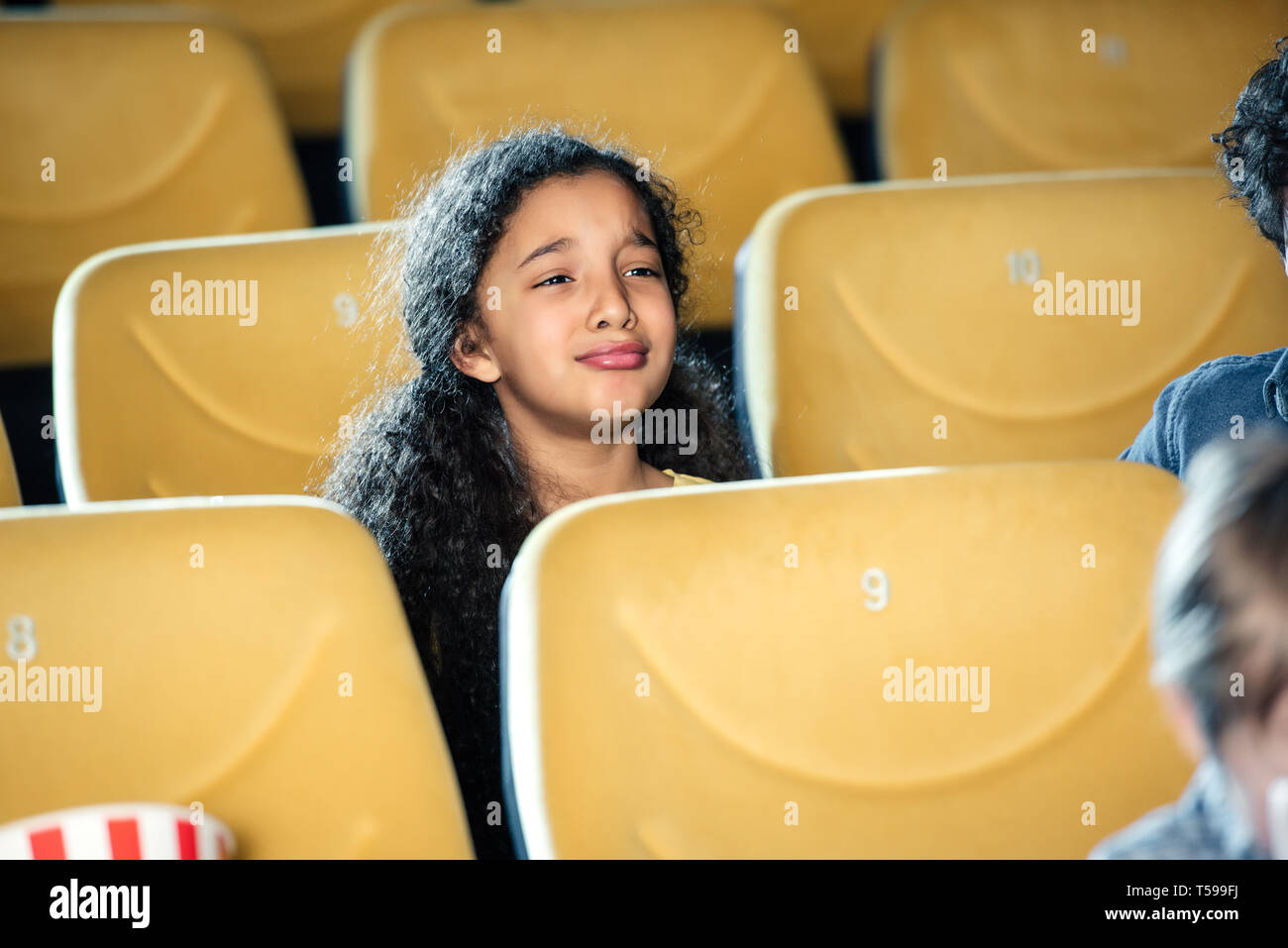 cute sad african american child crying while watching movie in cinema ...