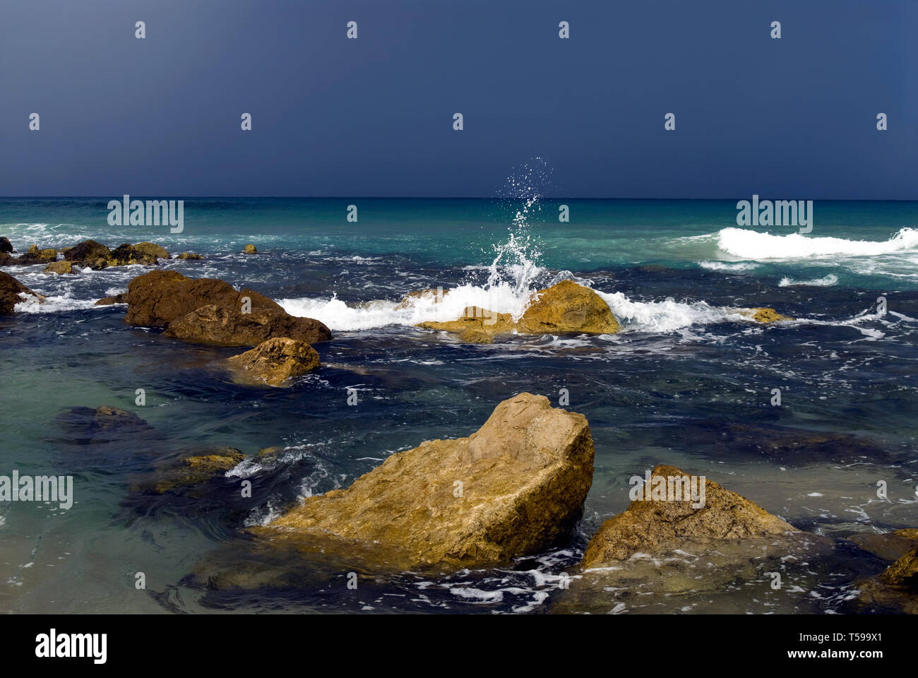Splashing surf, stones in water against stormy sky Stock Photo - Alamy