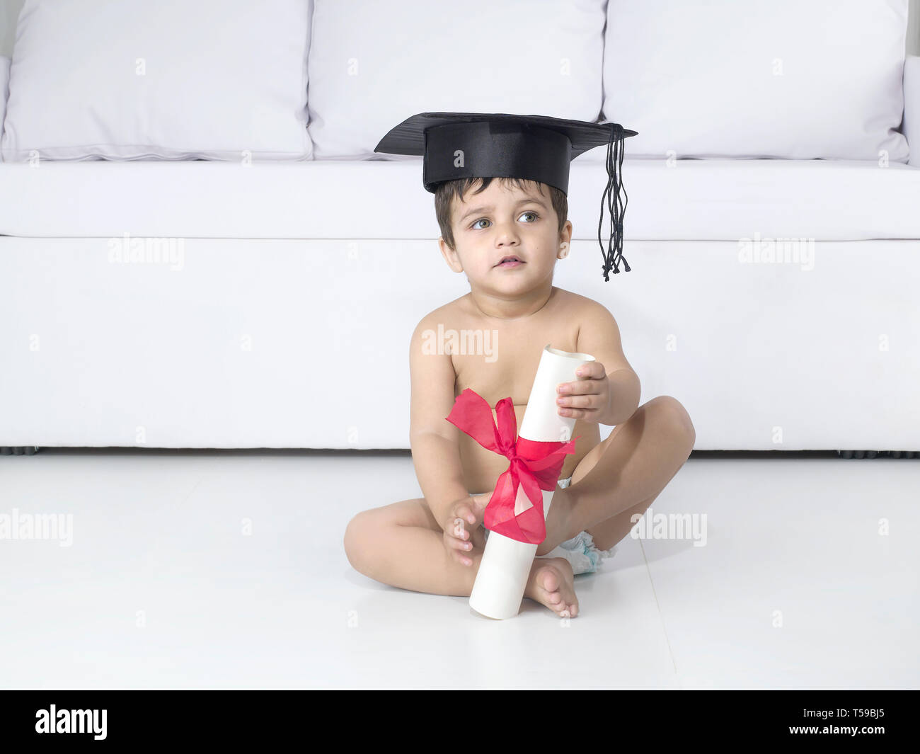 INFANT IN A DIAPER WEARING A GRADUATION HAT AND HOLDING A DEGREE ...