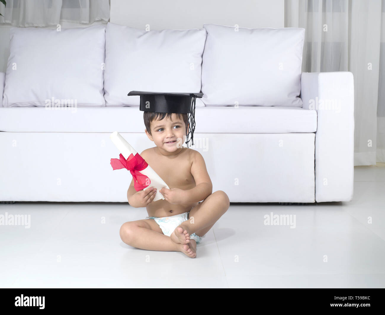 INFANT IN A DIAPER WEARING A GRADUATION HAT AND HOLDING A DEGREE ...