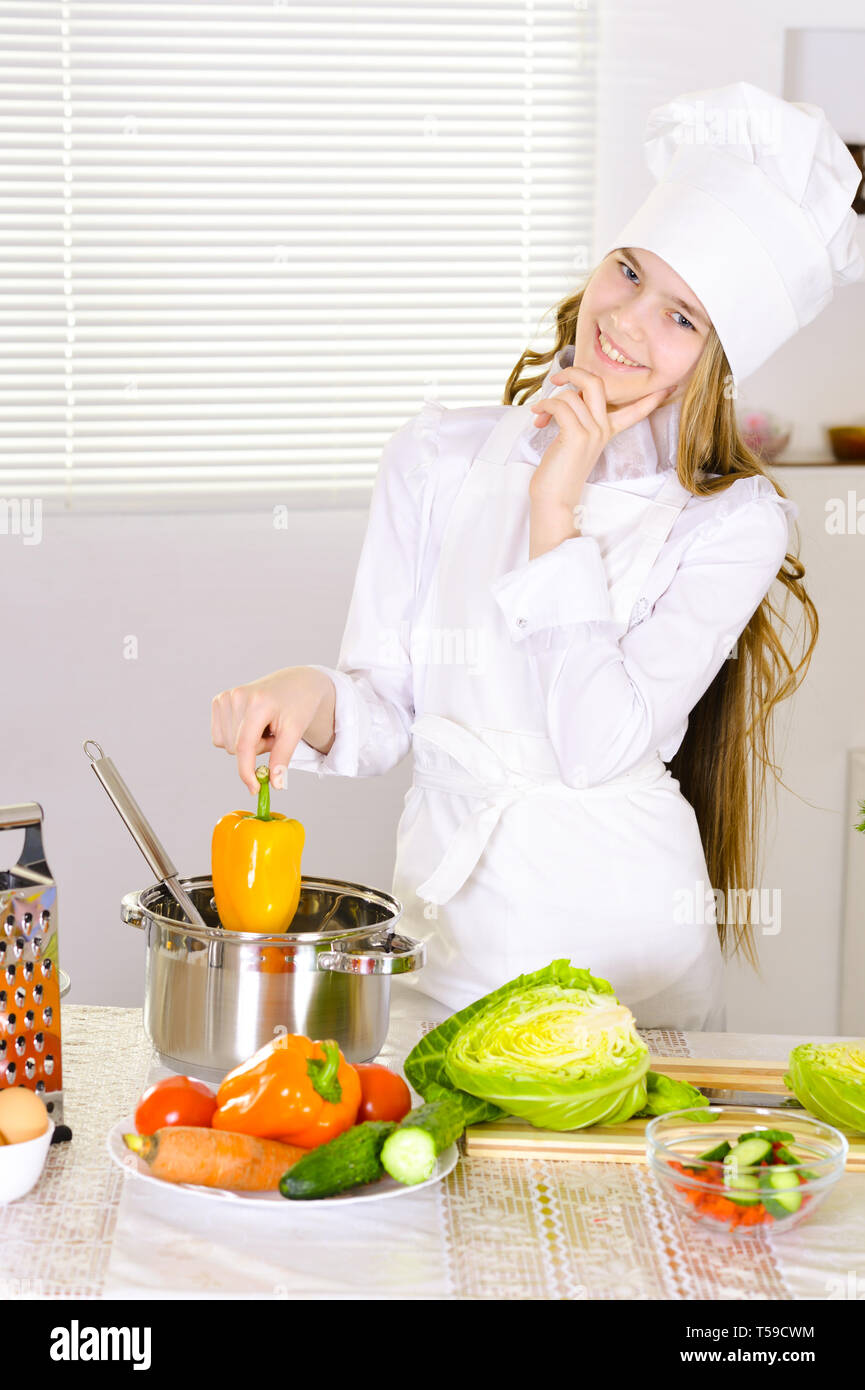 Girl wearing chef uniform cooking on kitchen Stock Photo - Alamy