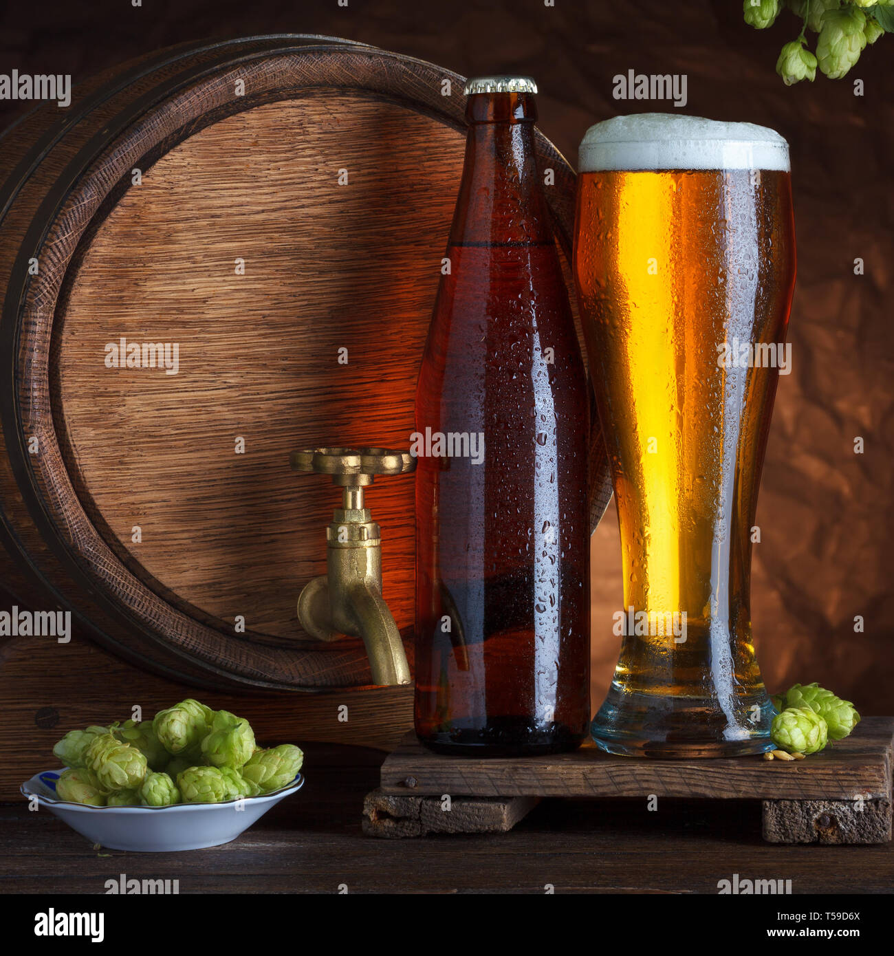 Beer glass and bottle with barrel and fresh hops Stock Photo - Alamy