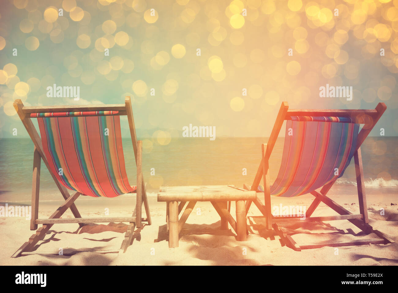 Beach chairs on sea shore with glowing bokeh and film stylized, double ...