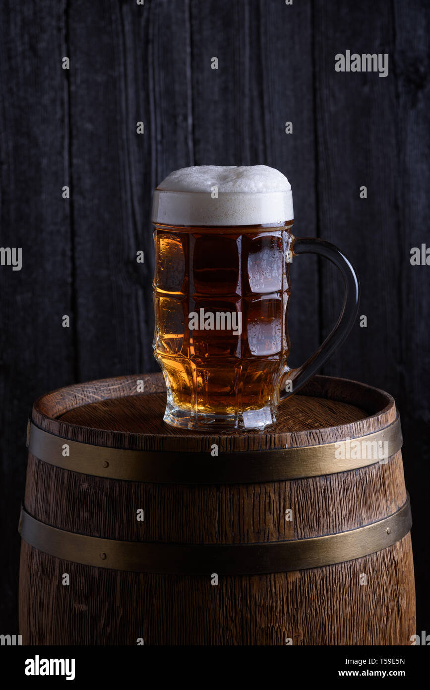 Beer glass on the top of old beer barrel dark still life Stock Photo ...