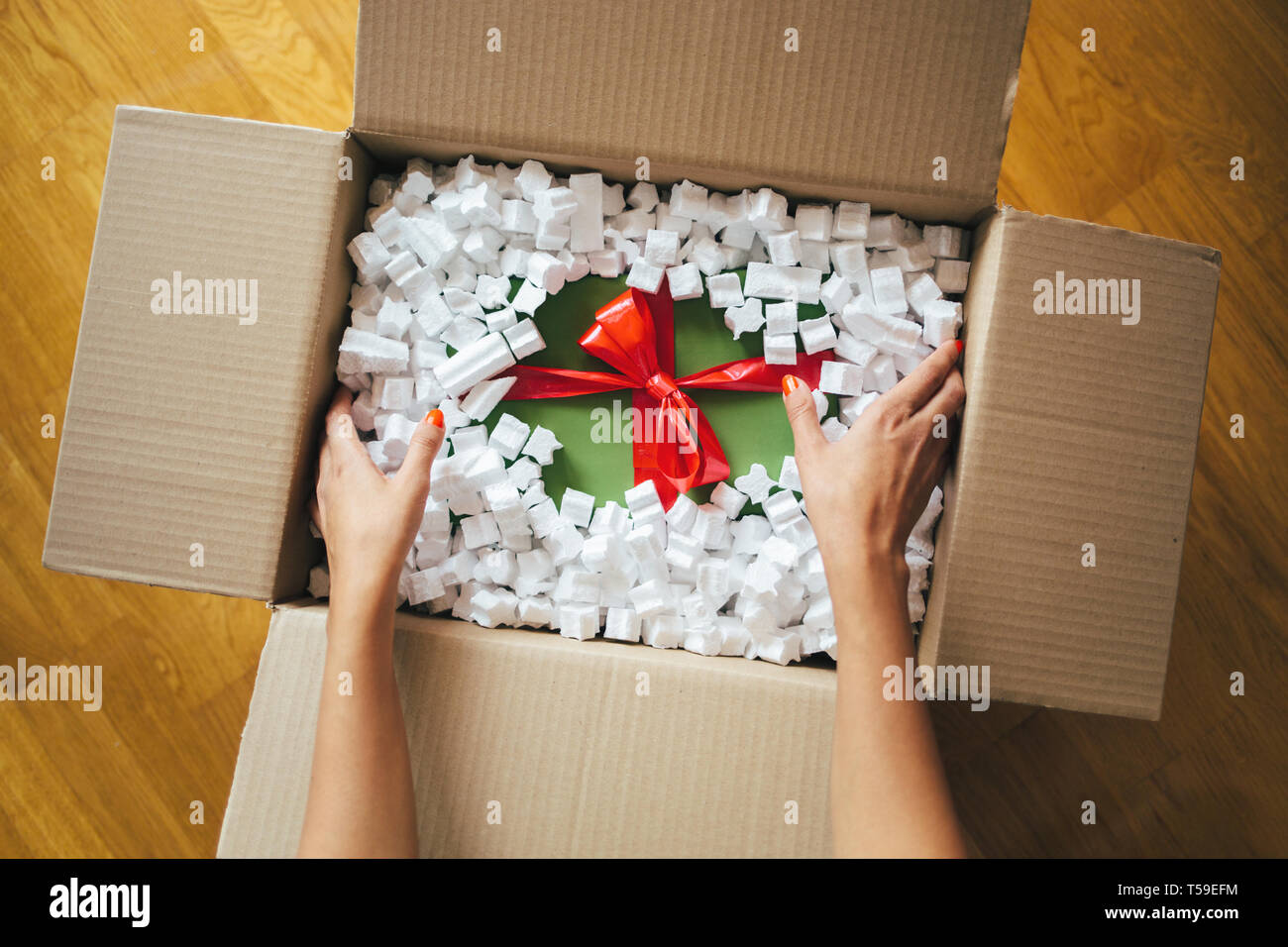 Woman hands opening a parcel contains a gift Stock Photo - Alamy