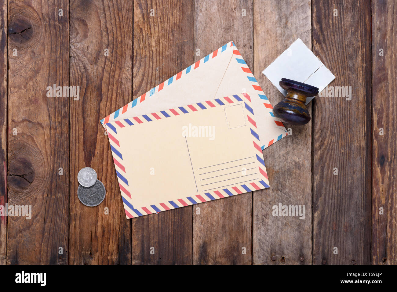 Post card with envelope and old stamp with coins on grunge wooden table ...