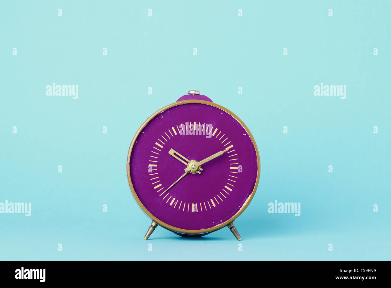 Old purple clock on blue background still life Stock Photo - Alamy