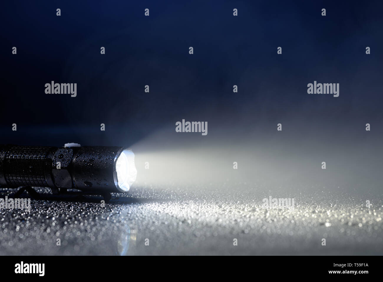 Tactical waterproof flashlight with water drops and fog Stock Photo - Alamy