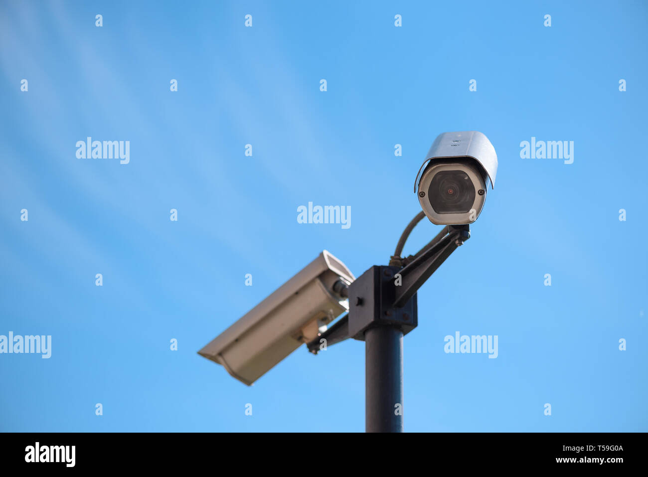 CCTV surveillance cameras on pillar mount over blue sky background ...