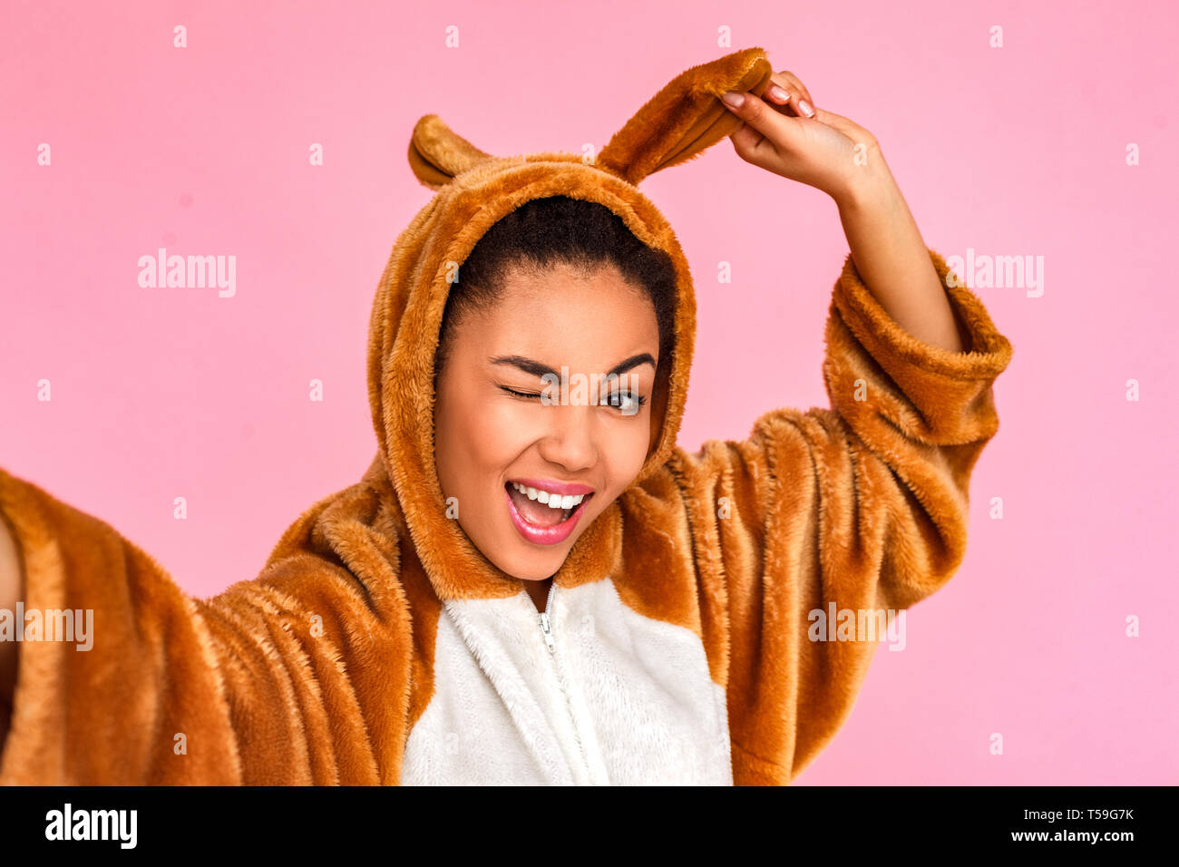 Young Woman In Bunny Kigurumi Standing Isolated On Pink Background