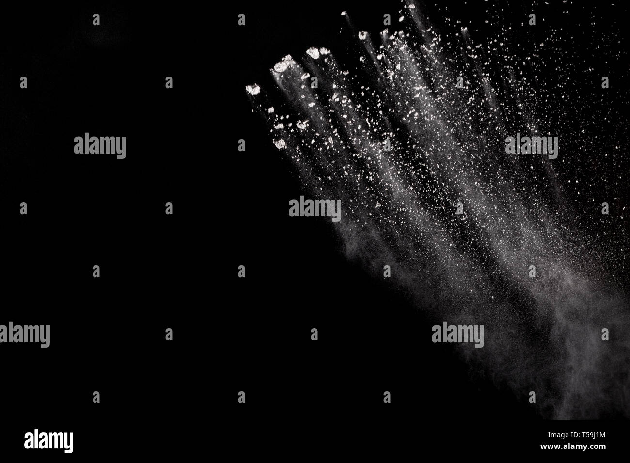 White dust particles exhale in the air. Motion powder burst in dark ...