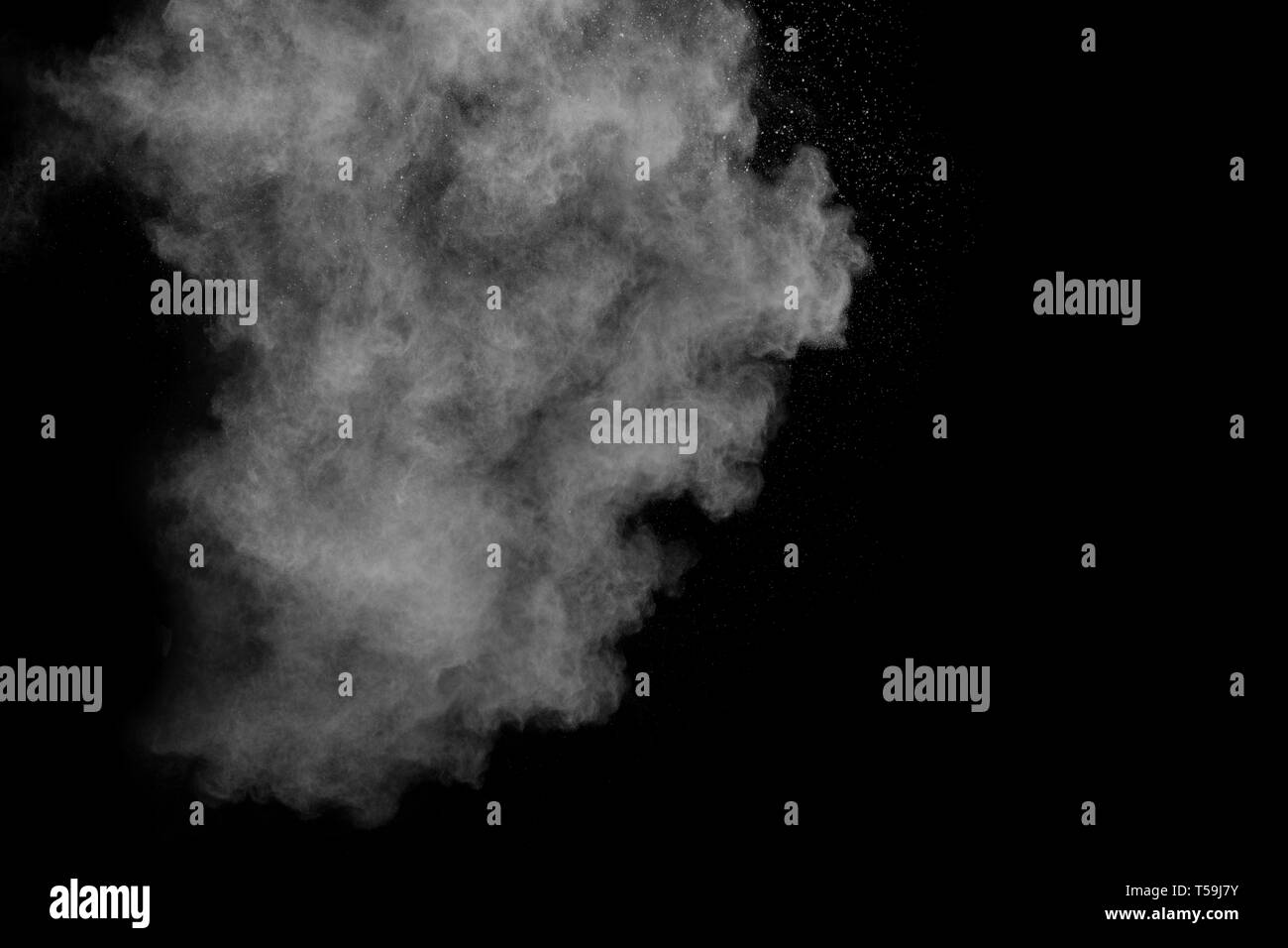 White dust particles exhale in the air. Motion powder burst in dark ...