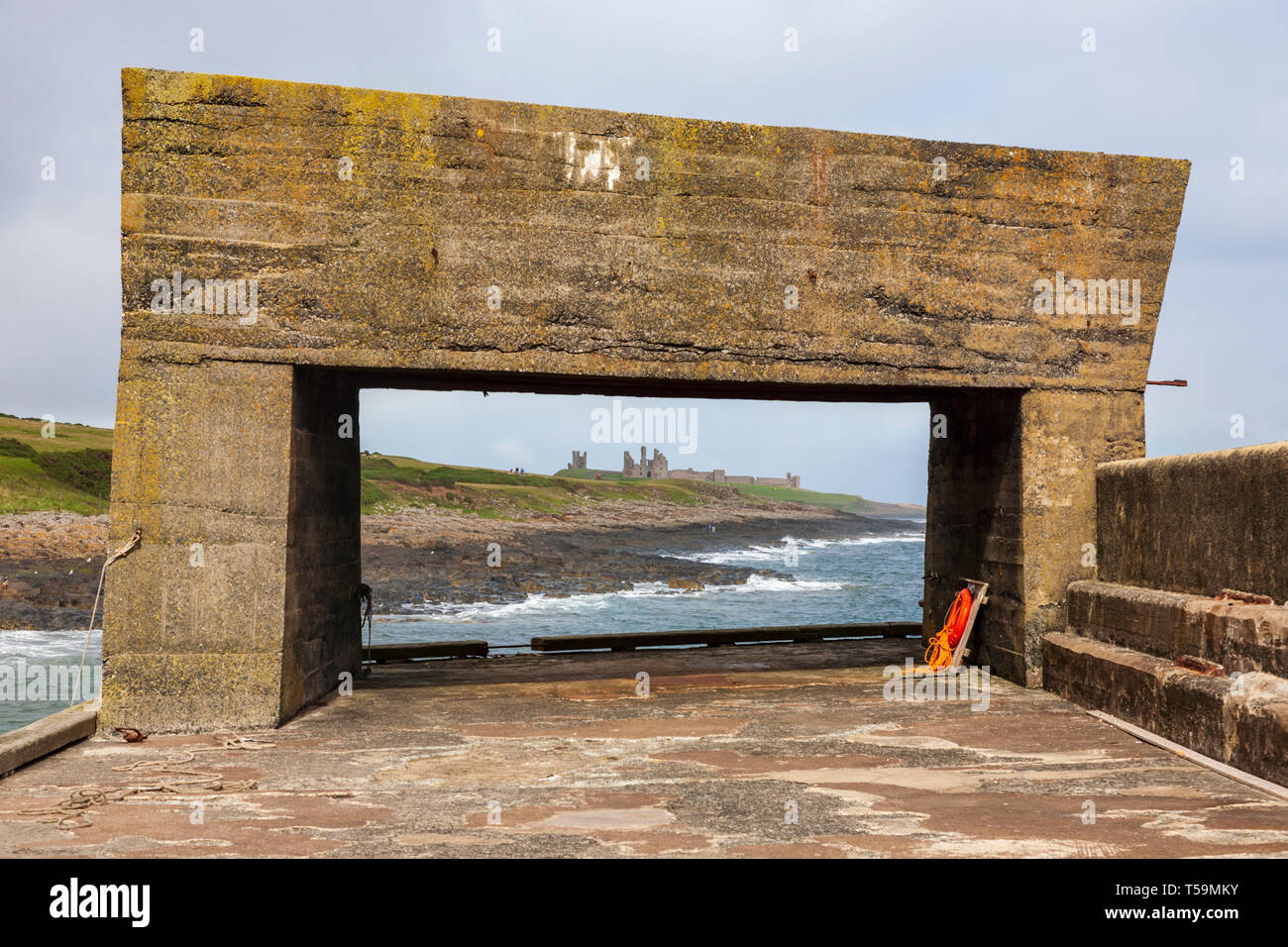 The remains of the harbour tower at Craster with a view through to ...