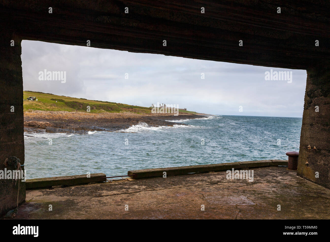 The remains of the harbour tower at Craster with a view through to ...