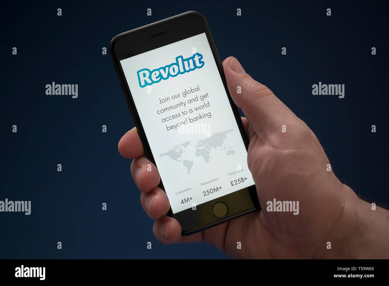 A man looks at his iPhone which displays the Revolut logo (Editorial ...