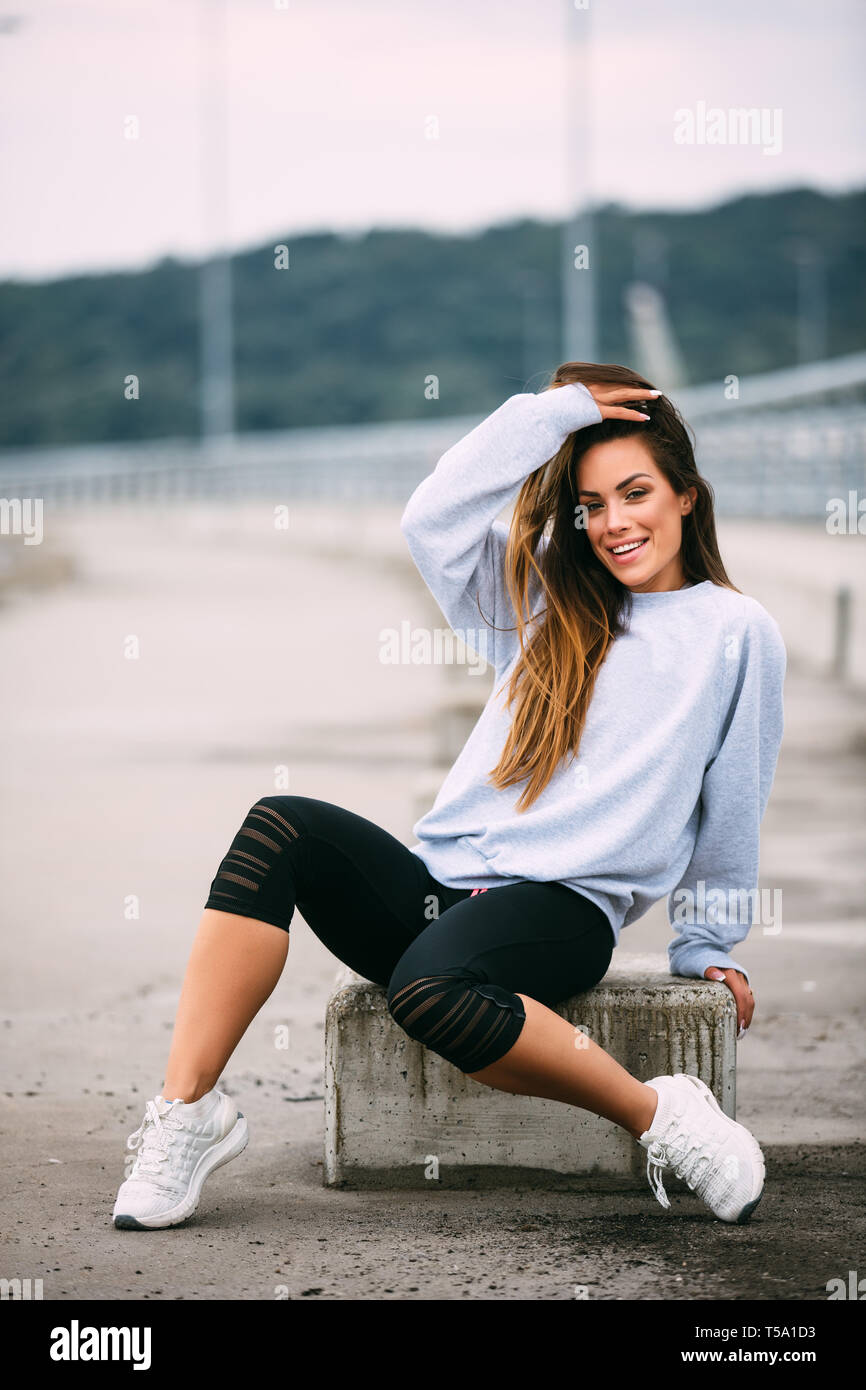 Portrait of a happy young fit woman smiling Stock Photo - Alamy