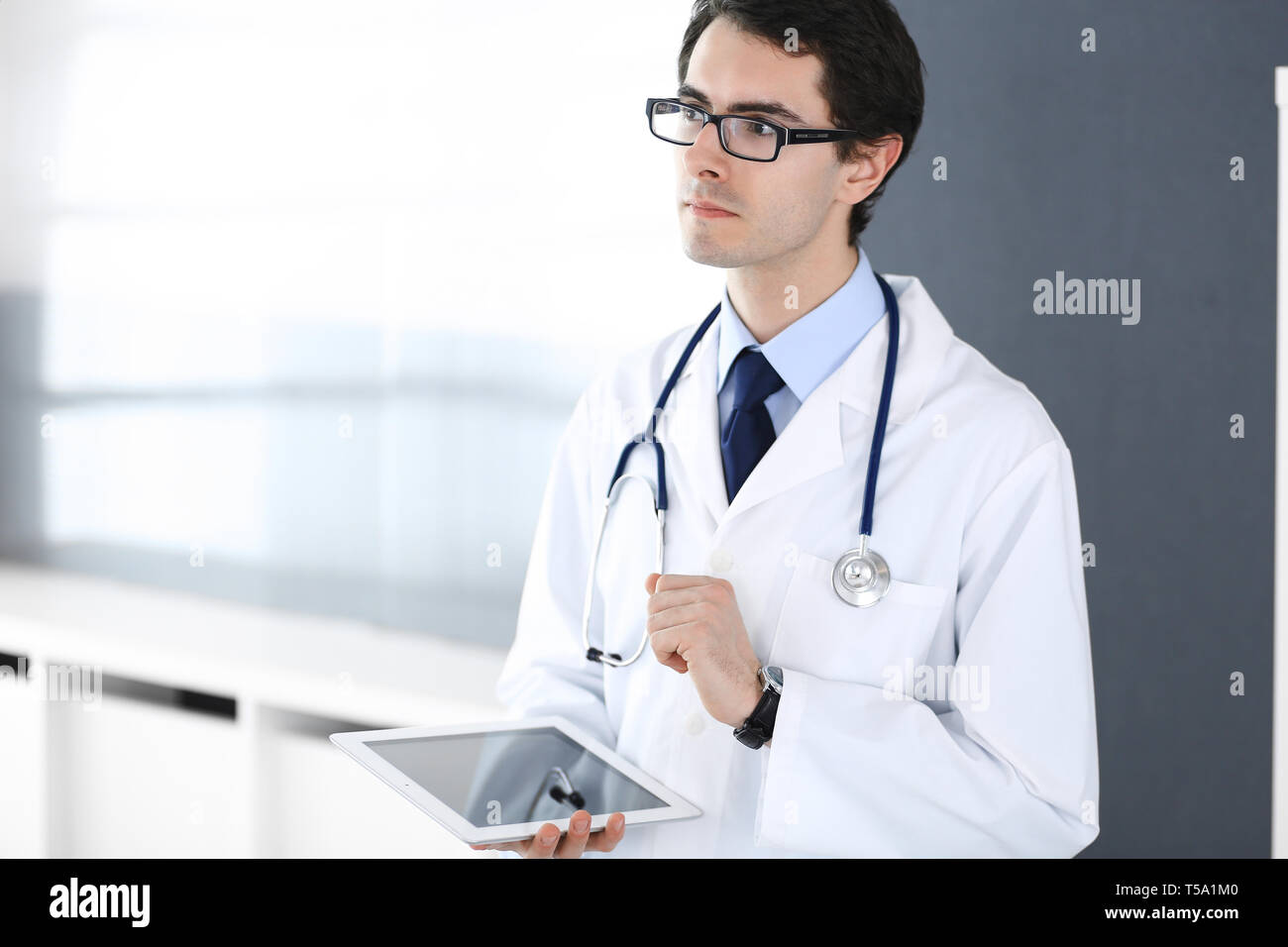 Doctor man using tablet computer for network research or virtual ...