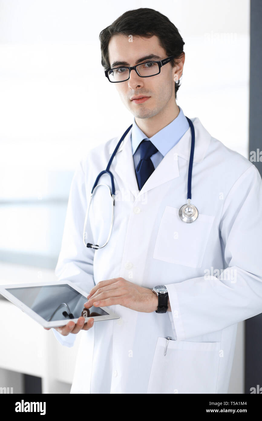 Doctor man using tablet computer for network research or virtual ...