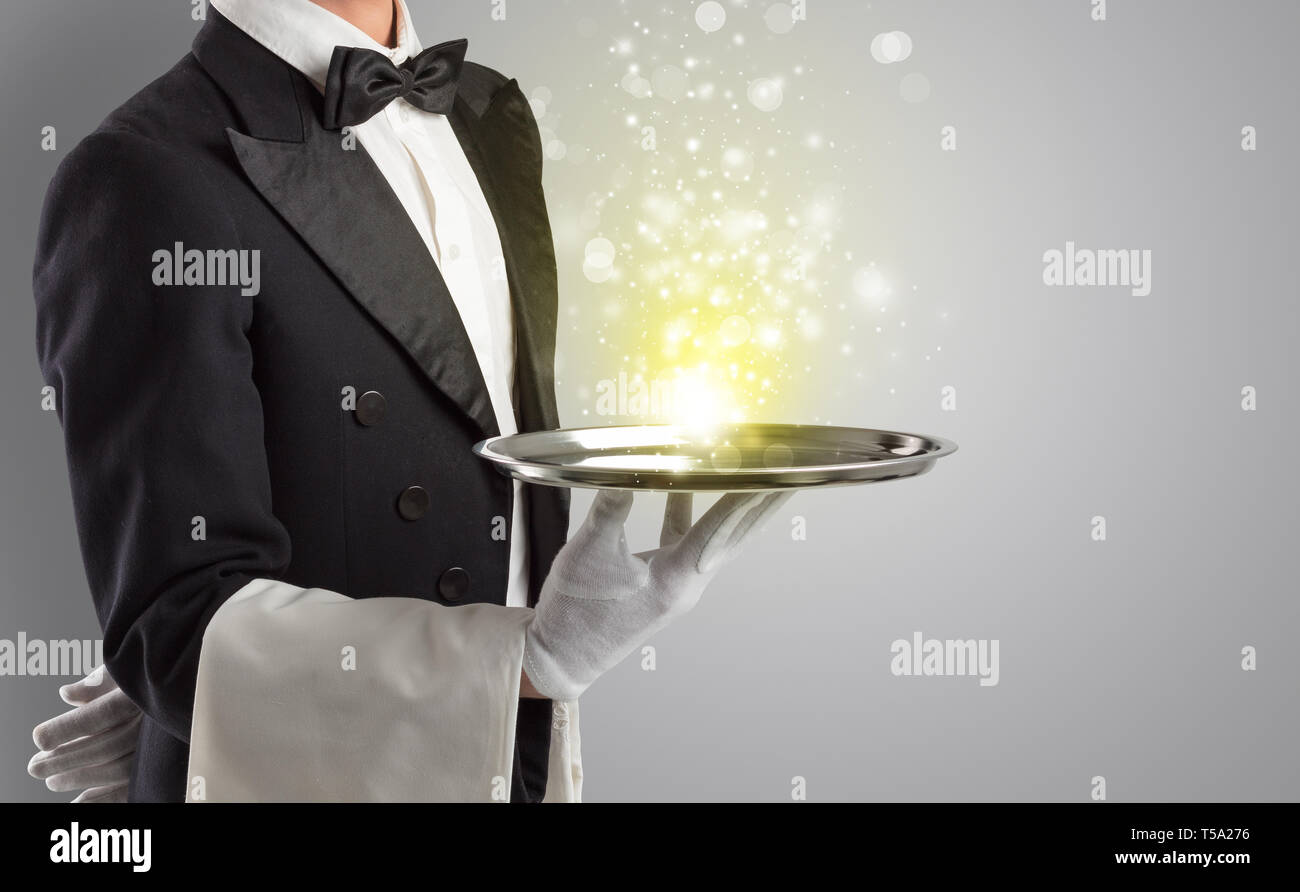 Elegant young waiter serving mysterious light on tray Stock Photo - Alamy