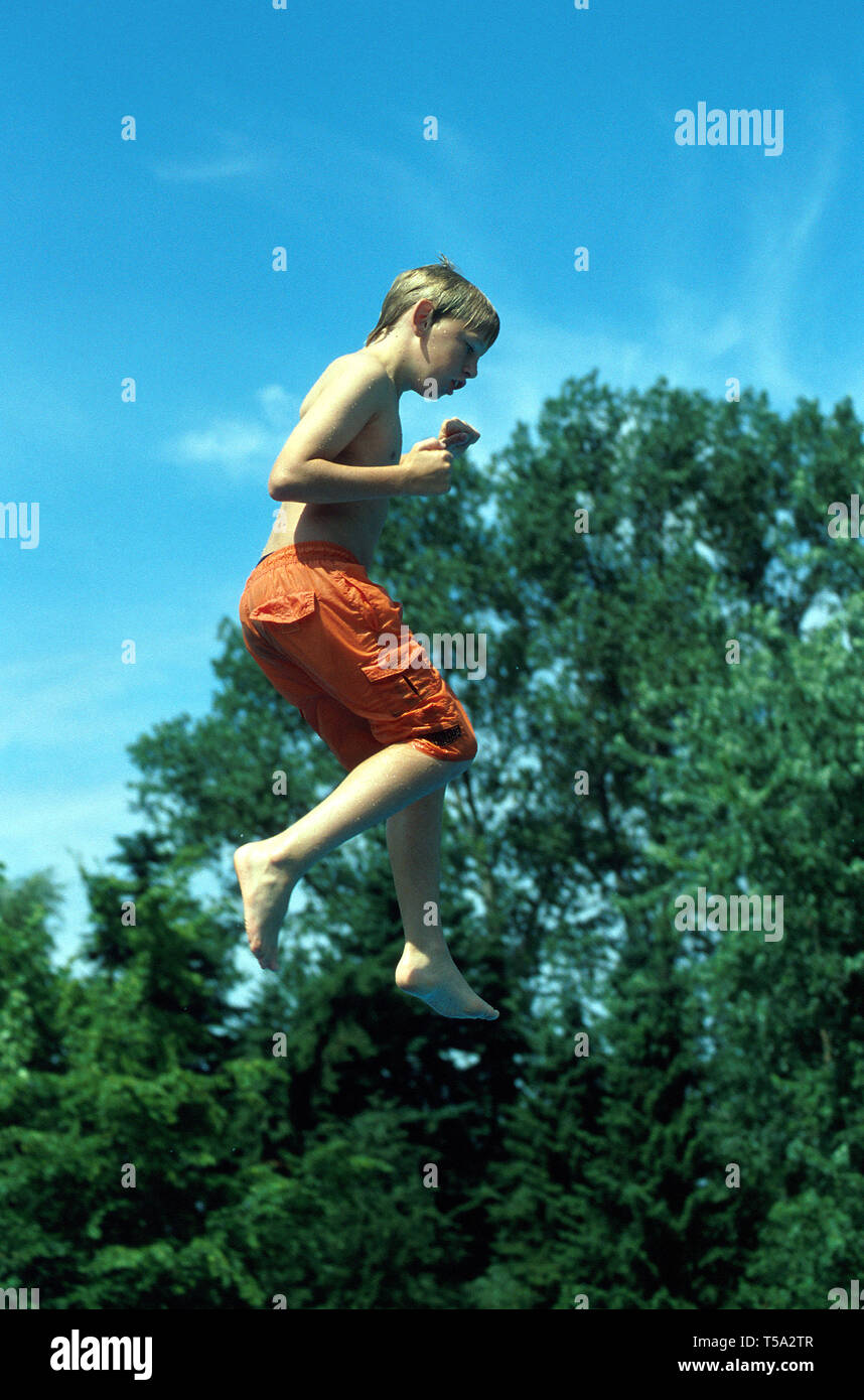 young boy jumping off a diving board Stock Photo - Alamy