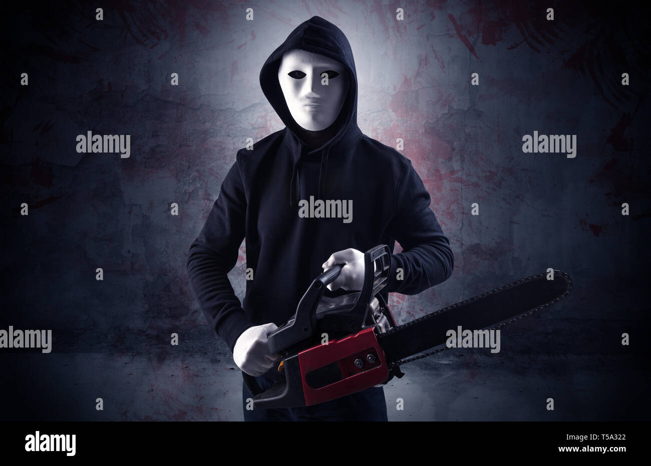 Armed rude assassin in an empty bloody room concept with gun ax ...