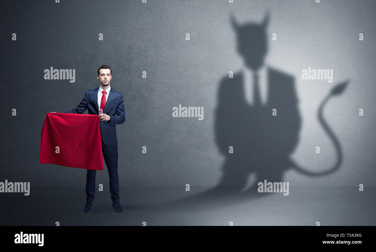 Businessman standing with red cloth in his hand and devil shadow on the ...