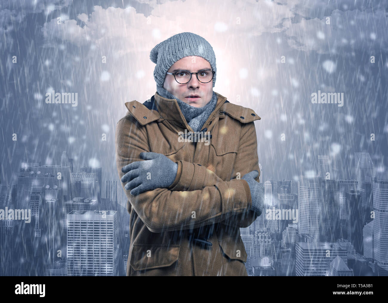 Young man freezing in warm clothing with city concept Stock Photo - Alamy