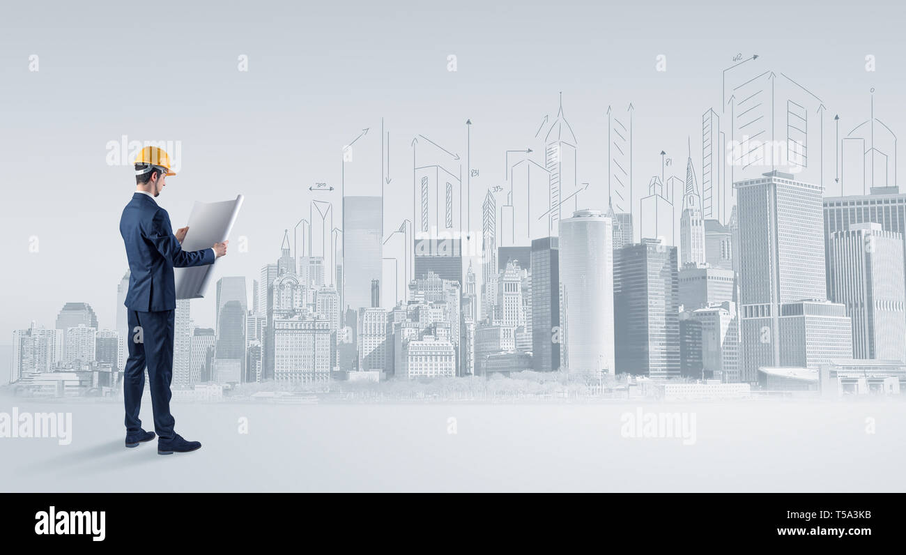 Young supervisor architect standing and replanning a big city panorama ...
