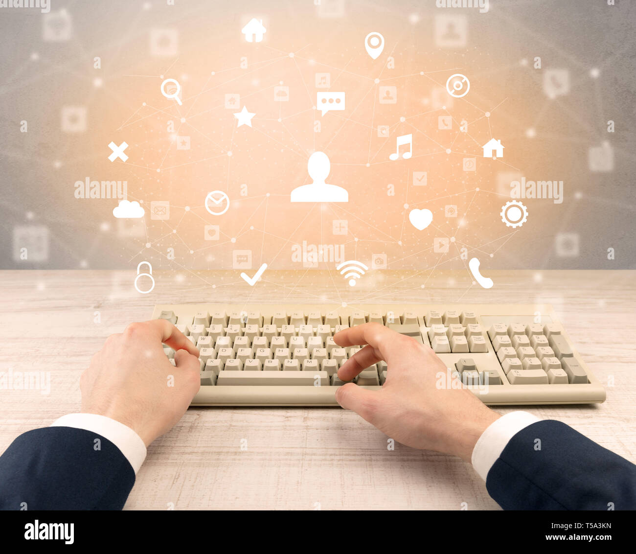 First person view of hand typing with social media concept icons around ...